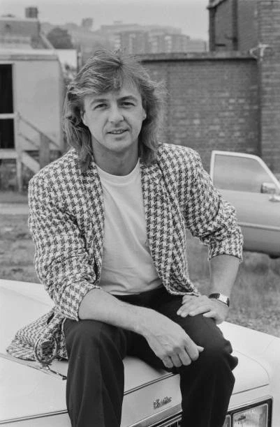 BRITISH SINGER BOBBY G of pop group Bucks Fizz sitting on a Cadilla ...