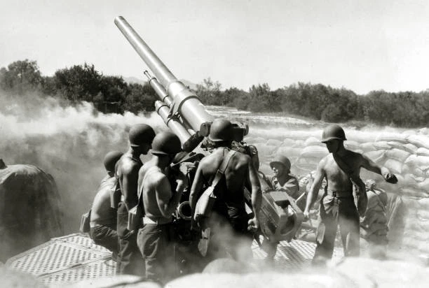 AN AMERICAN COAST artillery unit fire their heavy gun during al- 1942 ...