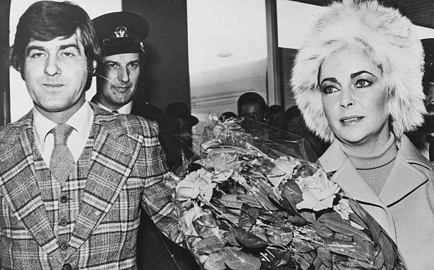 ACTRESS ELIZABETH TAYLOR holding a bouquet flowers as she arri- 1973 ...