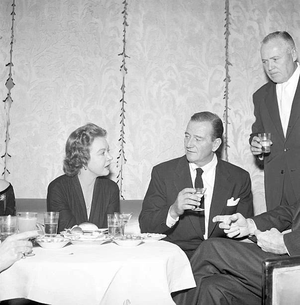 JOHN WAYNE AND director Henry Hathaway chatting at the cocktail 1957 ...