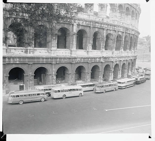 TOURIST BUSES ENCIRCLE the famed Colosseum in Rome, ready for - 1955 ...