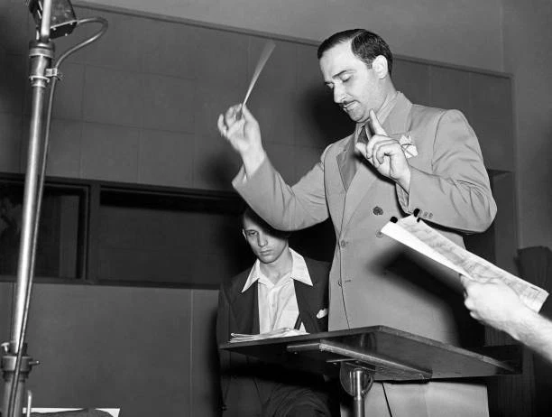RADIO CONDUCTOR JOHNNY Augustine is photographed while conductin 1940s ...