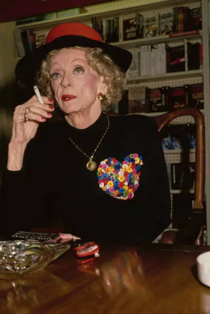 BETTE DAVIS WEARING a red-and-black hat a black outfit a heart mot- Old ...