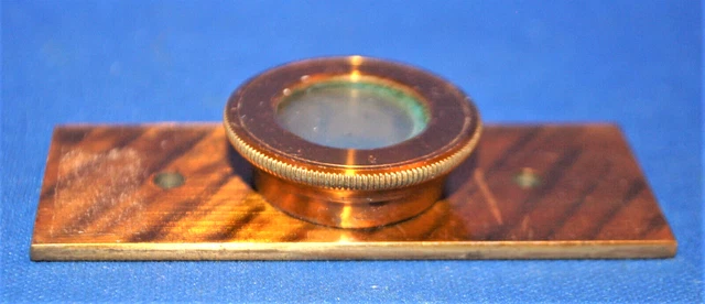A 19TH CENTURY brass microscope live box, single glass with top ring ...