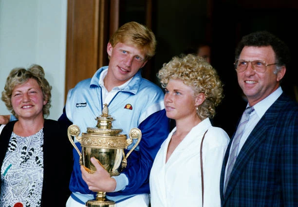 BORIS BECKER OF West Germany with the trophy, surrounded by his f - Old ...