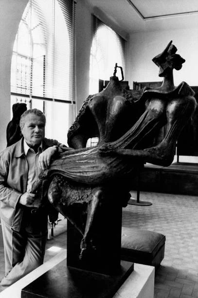 ITALIAN SCULPTOR LUCIANO Minguzzi posing beside the sculpted group ...