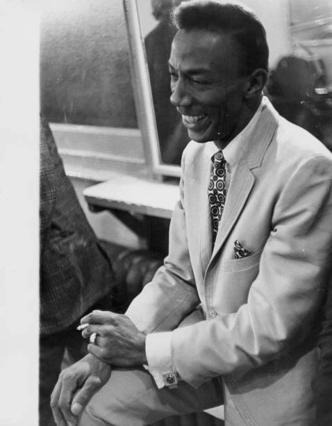 AMERICAN SINGER LEE Dorsey laughing and smoking a cigarette, on- 1955 ...