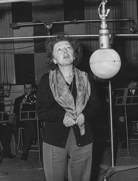 SINGER EDITH PIAF singing to a microphone during first recordin- 1962 ...