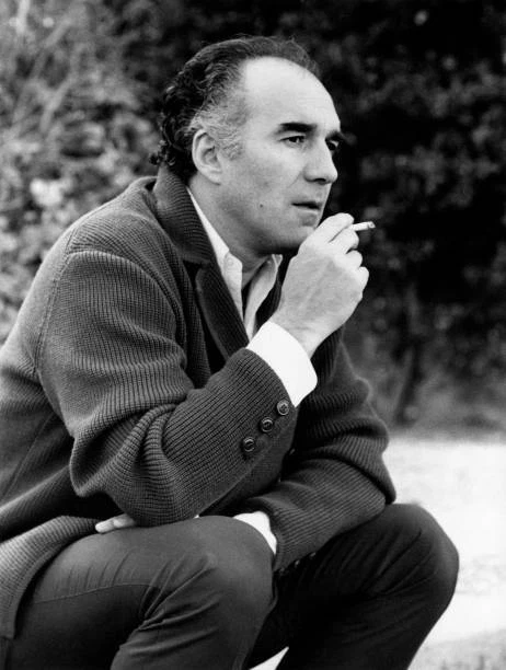 FRENCH ACTOR MICHEL Piccoli, sat down, is smoking a cigarette Rom- 1970 ...