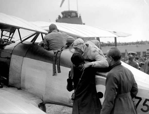 CO-PILOT LEANS OUT his cockpit, kissing a woman after completing K ...